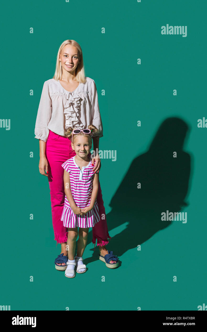 Portrait smiling mother and daughter against green background Stock ...