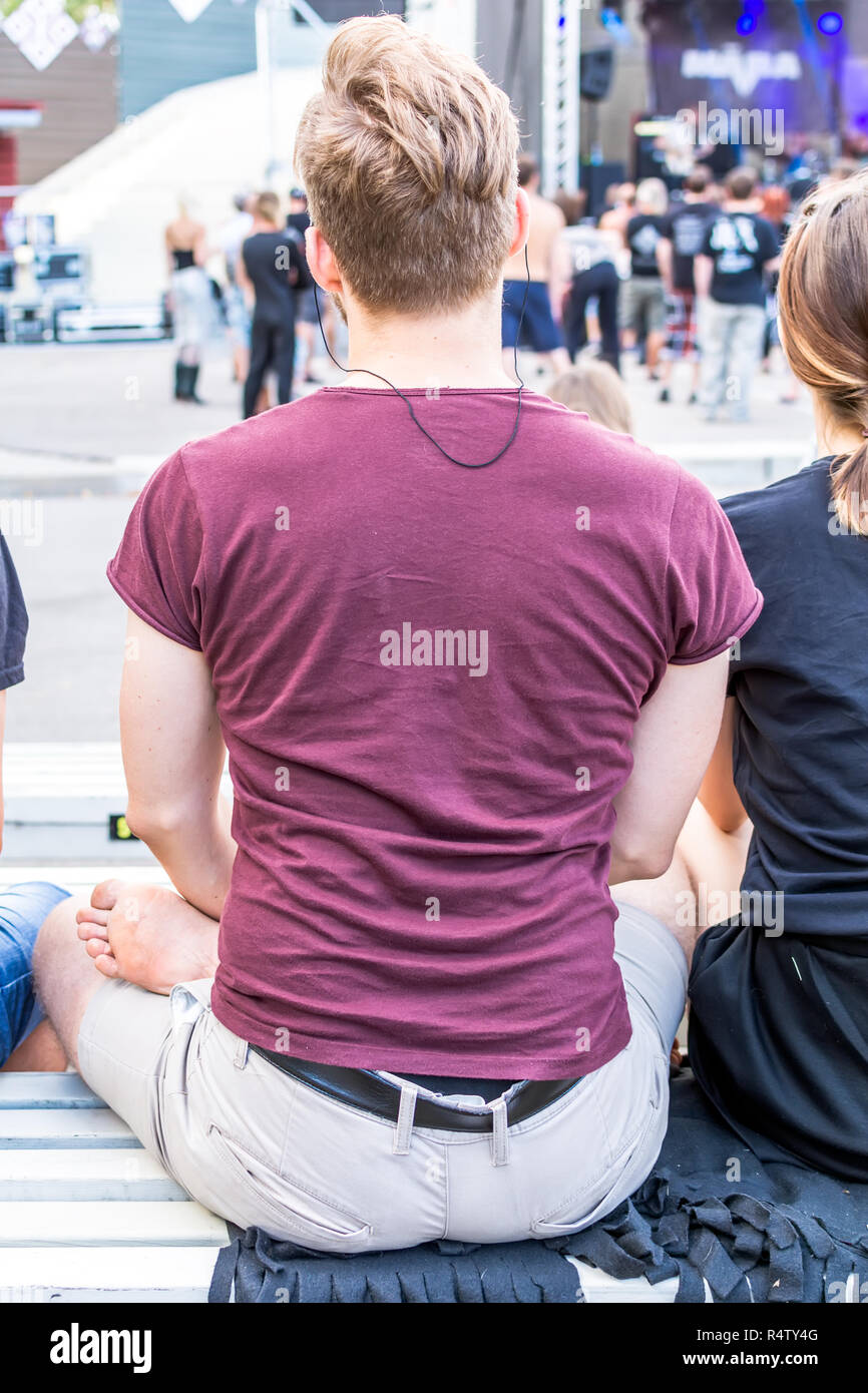 Heavy metal fan sitting in the lotus position and looking at stage ...