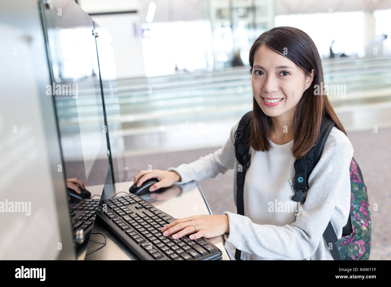 Woman searching on computer in the airport Stock Photo - Alamy