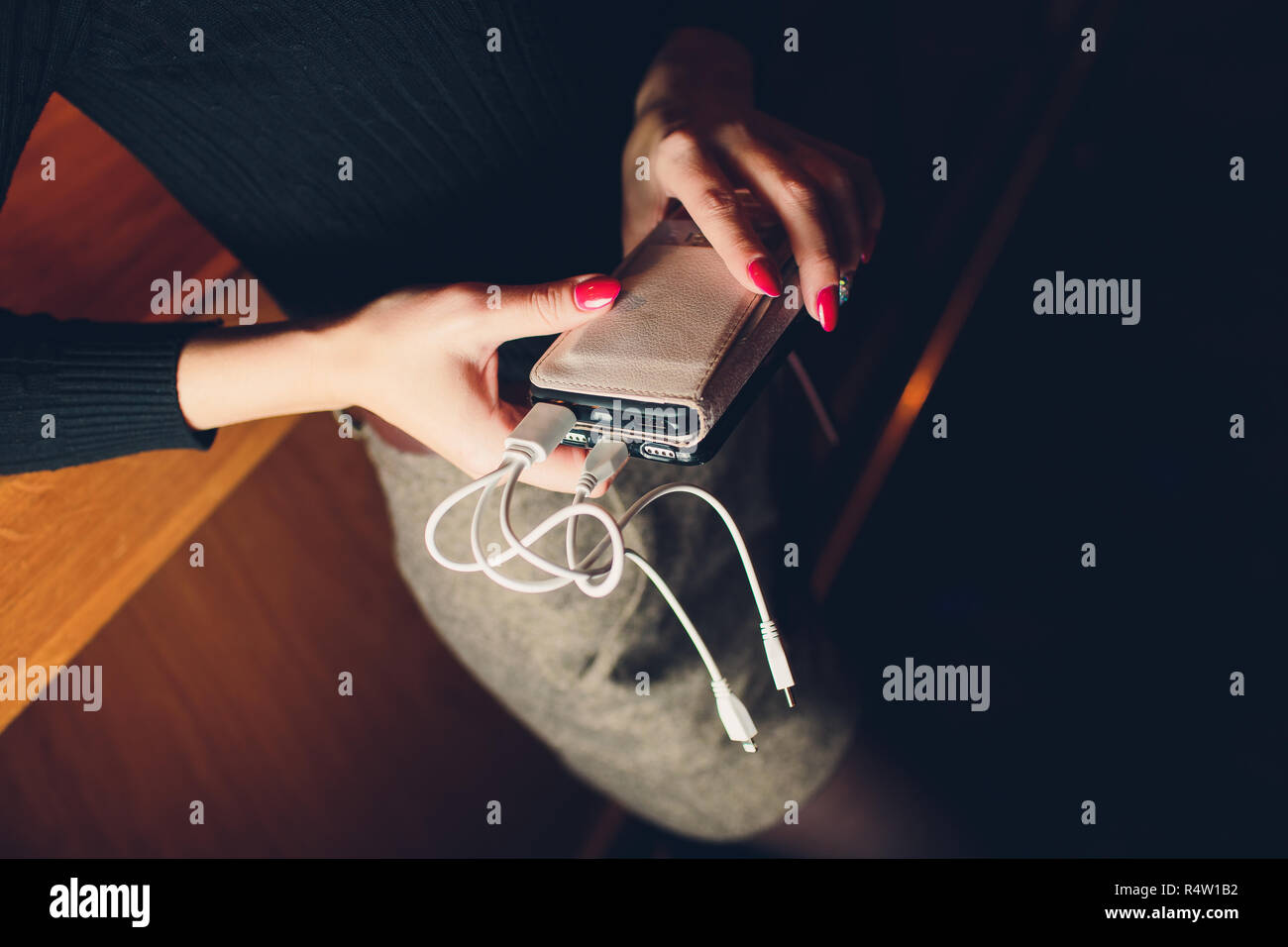 Hands of woman charging smartphone mobile phone device with cable and ...