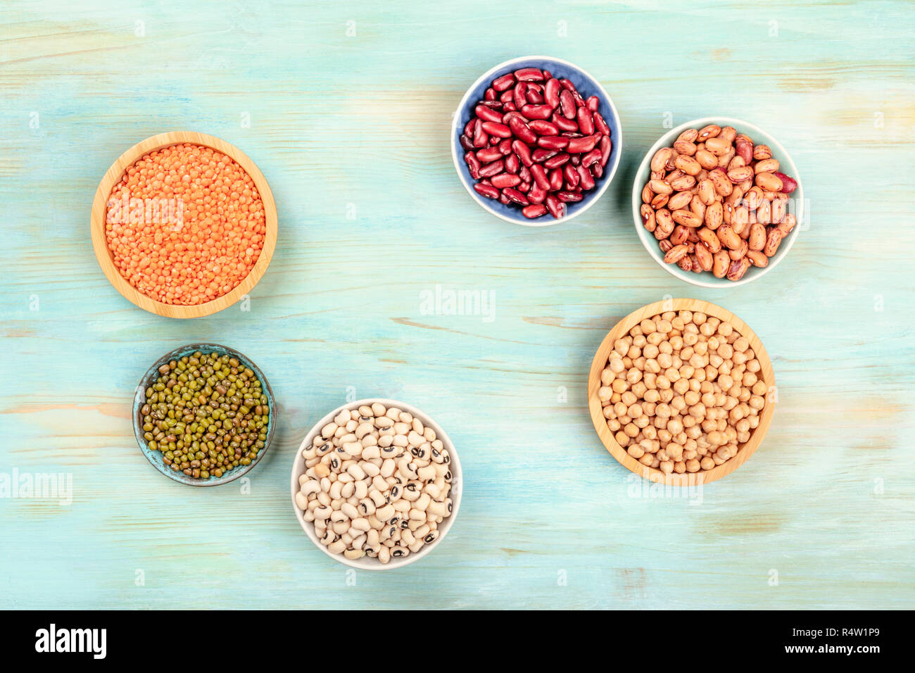 Various types of pulses, shot from above on a teal background with copy ...