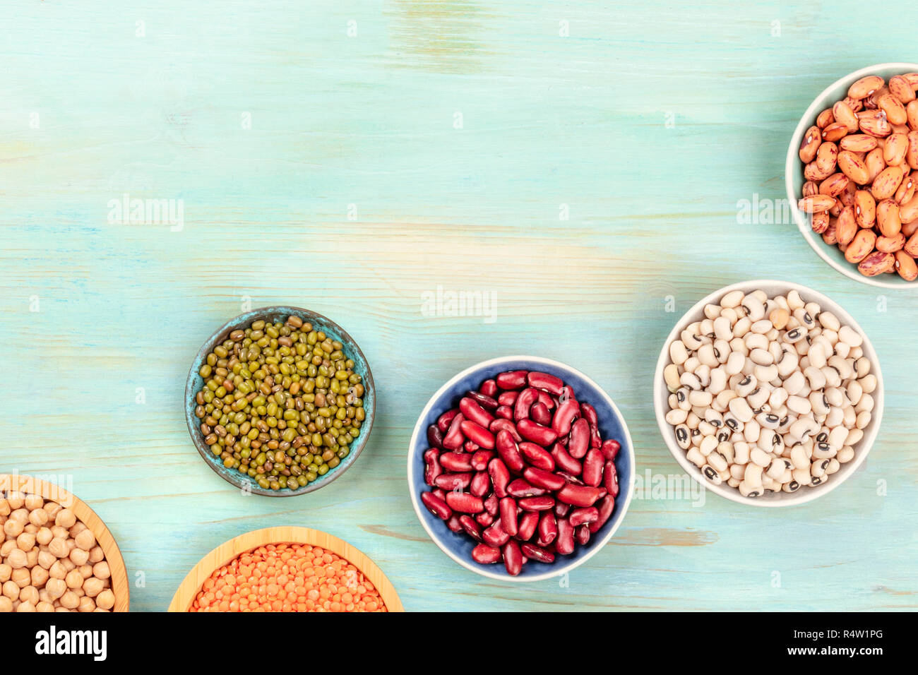 Various types of pulses, shot from the top on a teal background with a ...