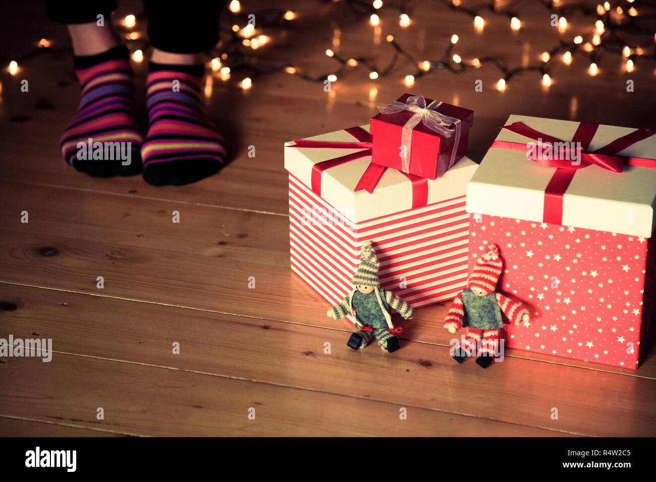 red gift boxes feet and christmas lights on wooden floor Stock Photo ...