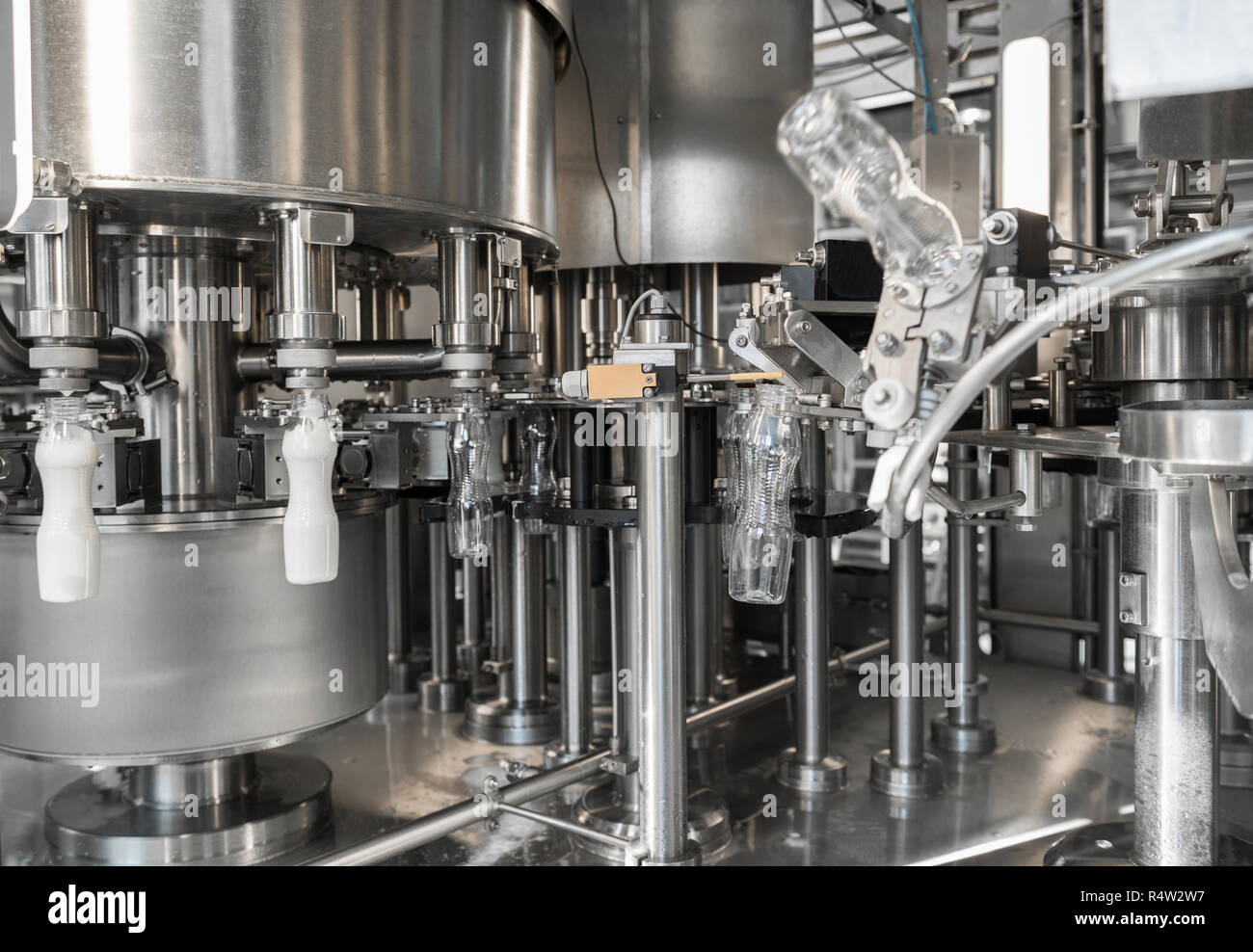 filling milk in to plastic bottles at the factory. equipment at the ...