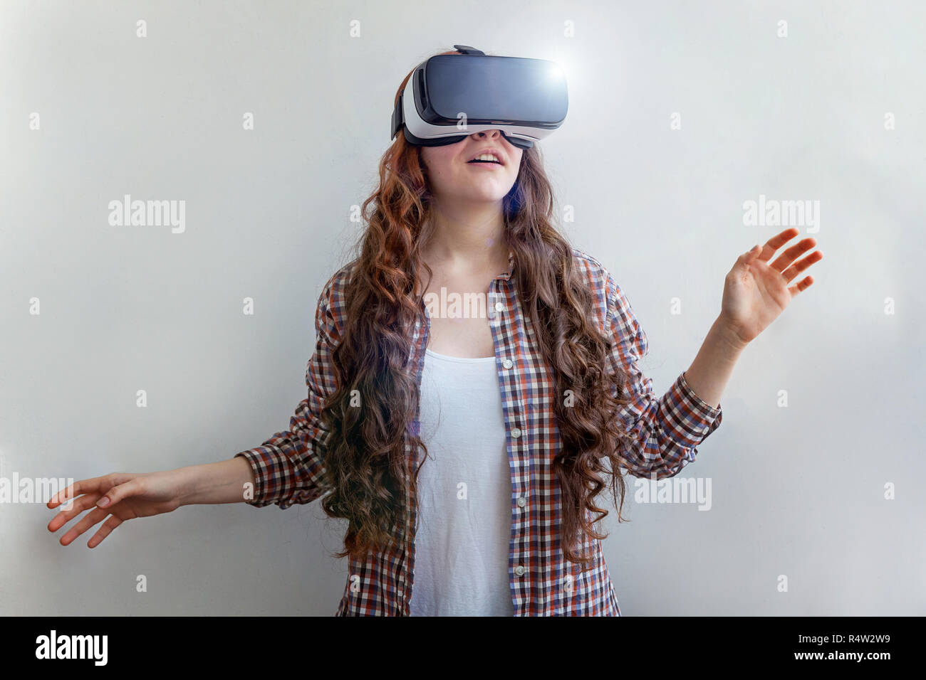 Smile young woman wearing using virtual reality VR glasses helmet headset on white background ...