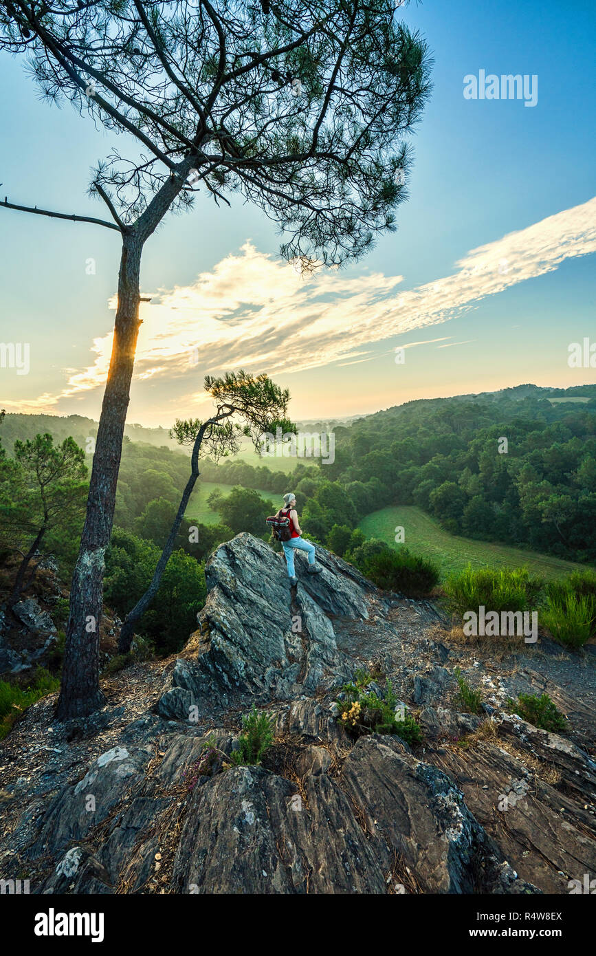 A woman walking on a mountain trail looks down the valley Stock Photo ...