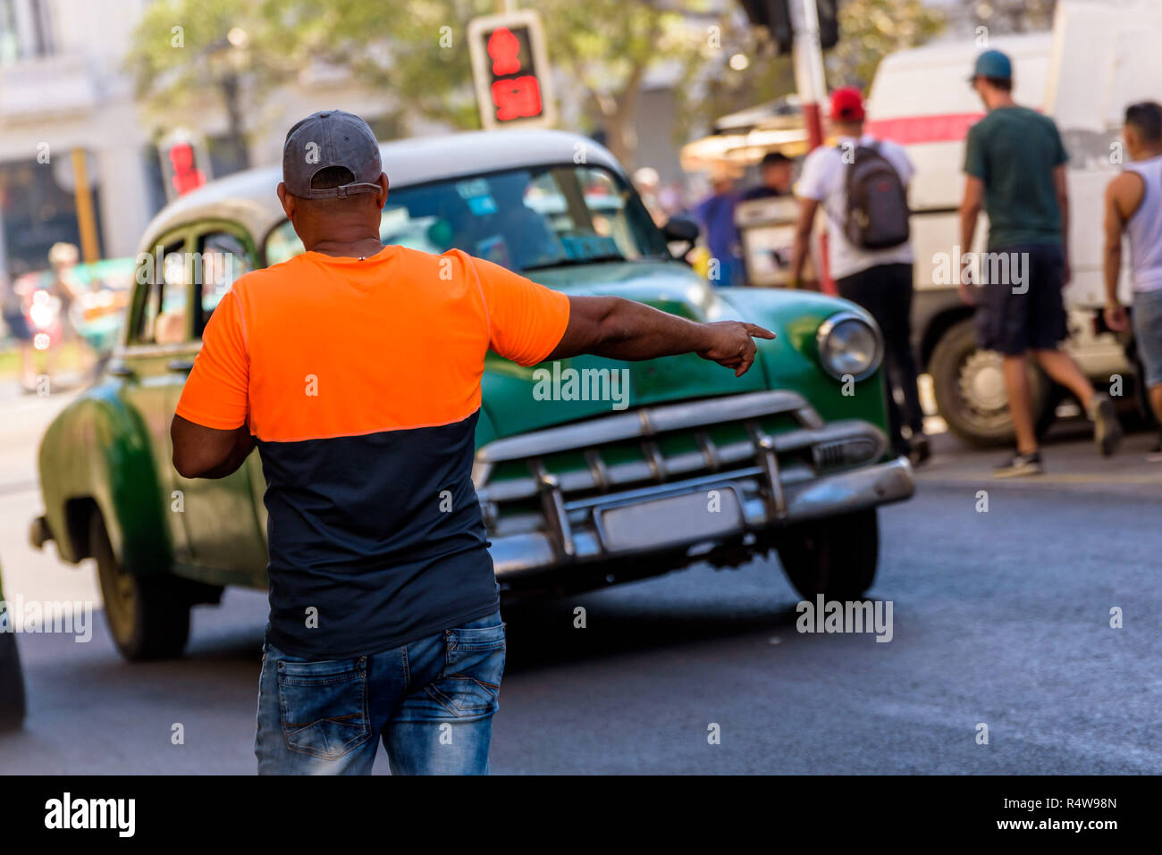 Cuban man raising hand calling a collective taxi in Old Havana. Young ...