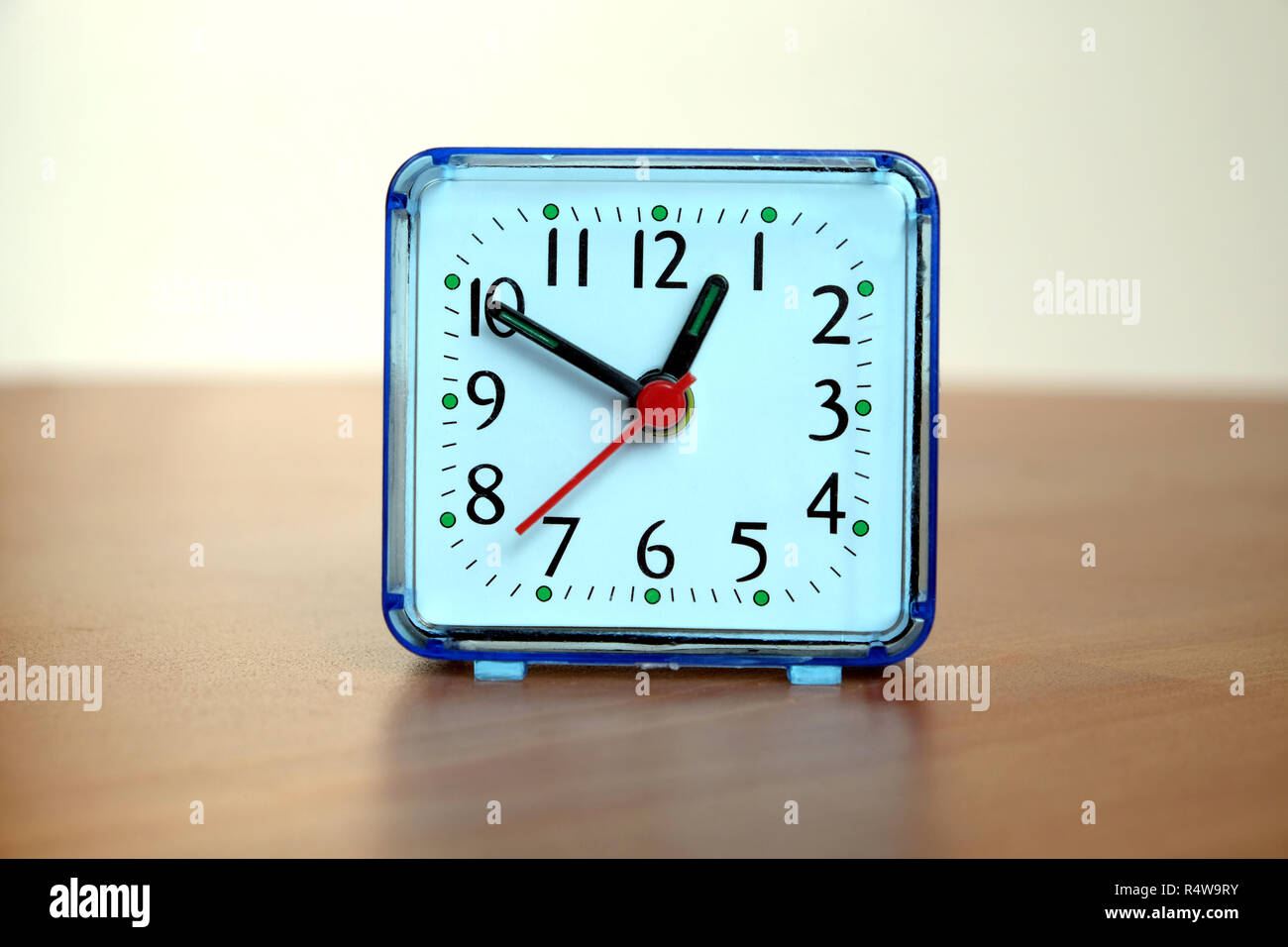 Table alarm clock square shape showing one o'clock on a table front ...