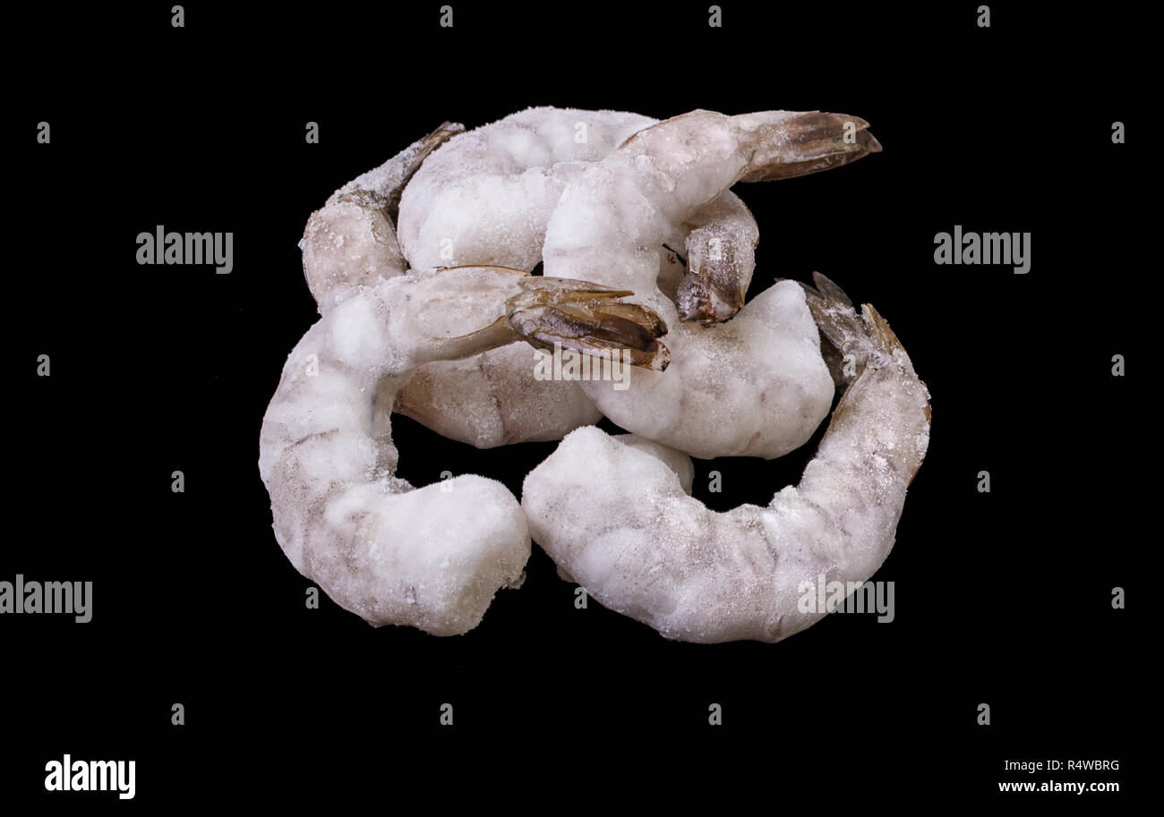 A bunch of raw frozen prawn isolated on black background, front view ...