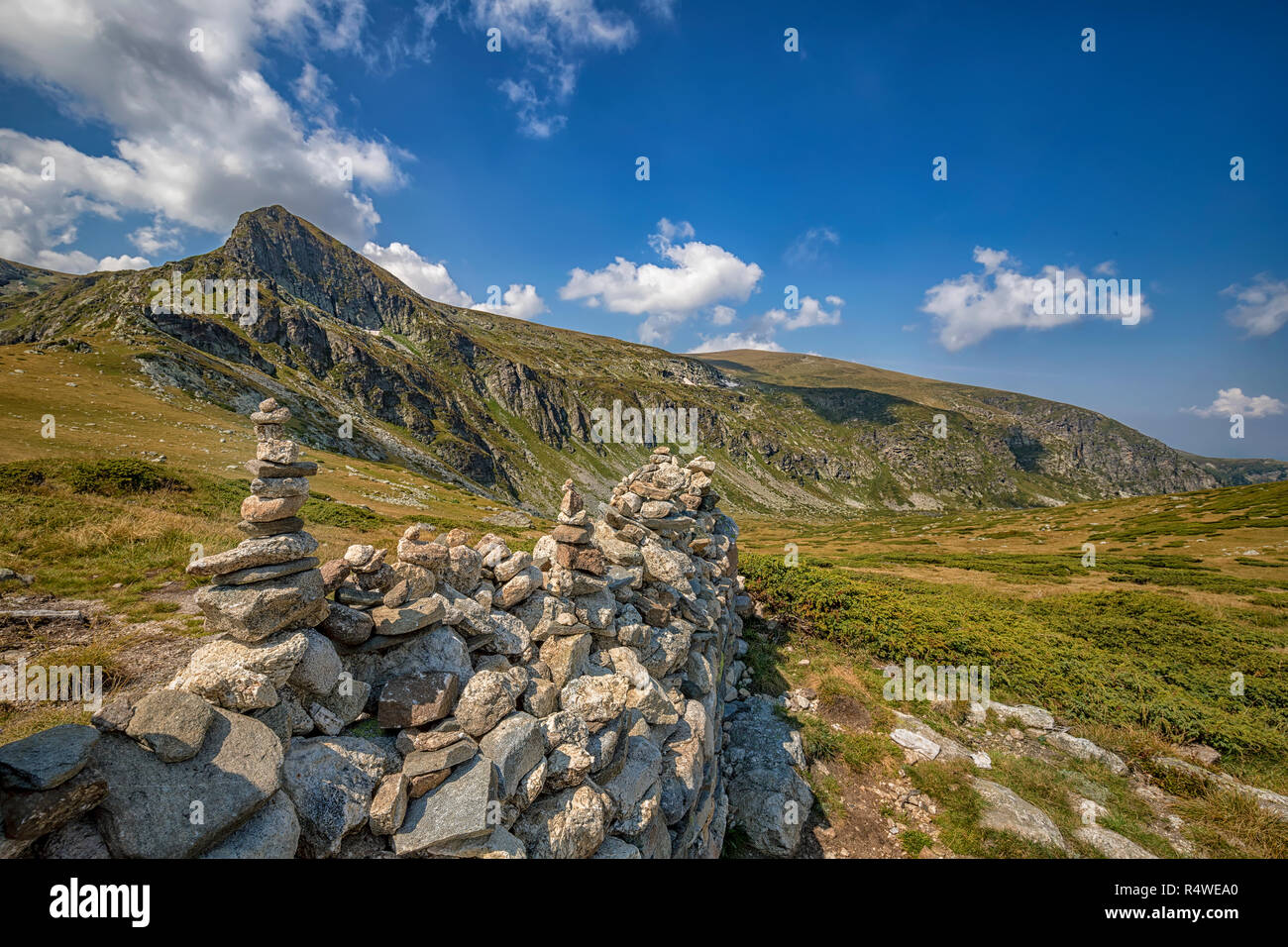 Stone pyramids and stone wall marking hiking paths in the Rila ...
