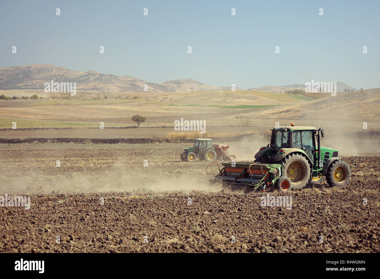 Tractors cultivating a field near Stock Photo - Alamy