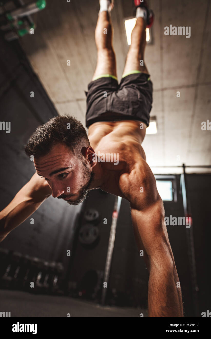 Young muscular man doing hard exercise at the gym. His is doing ...
