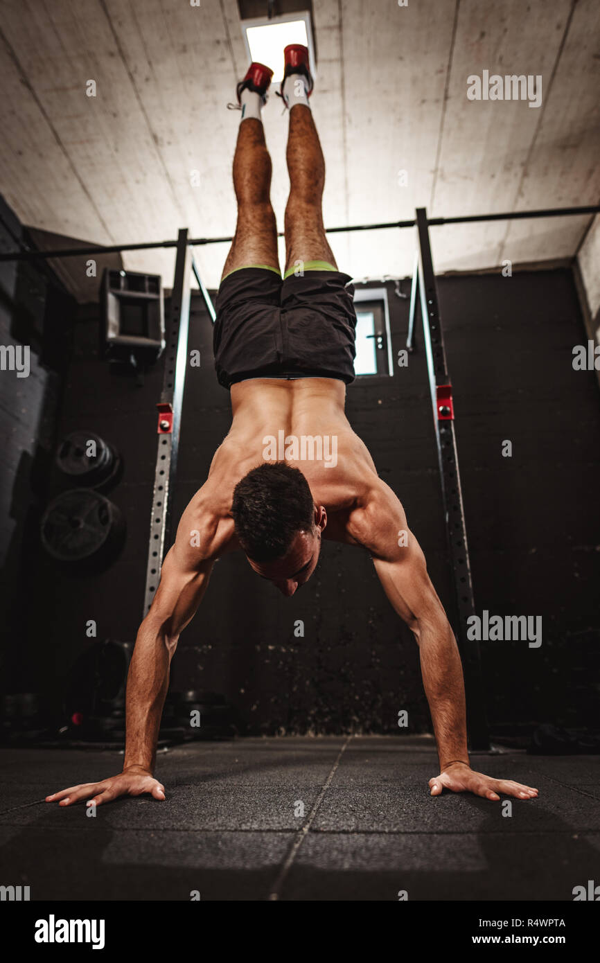 Young muscular man doing hard exercise at the gym. His is doing ...