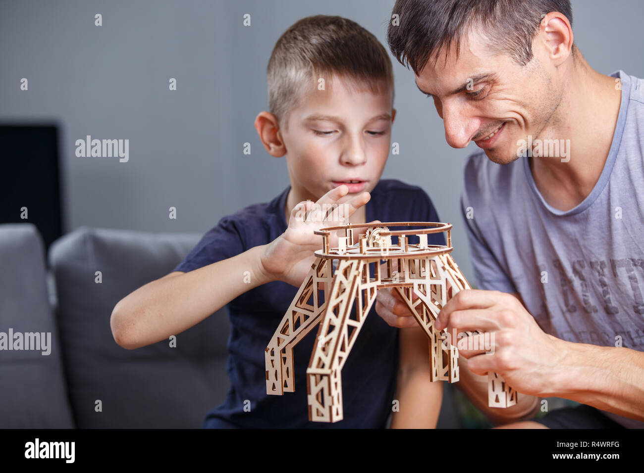 Young boy assembling wooden constructor with his father. Eco building ...