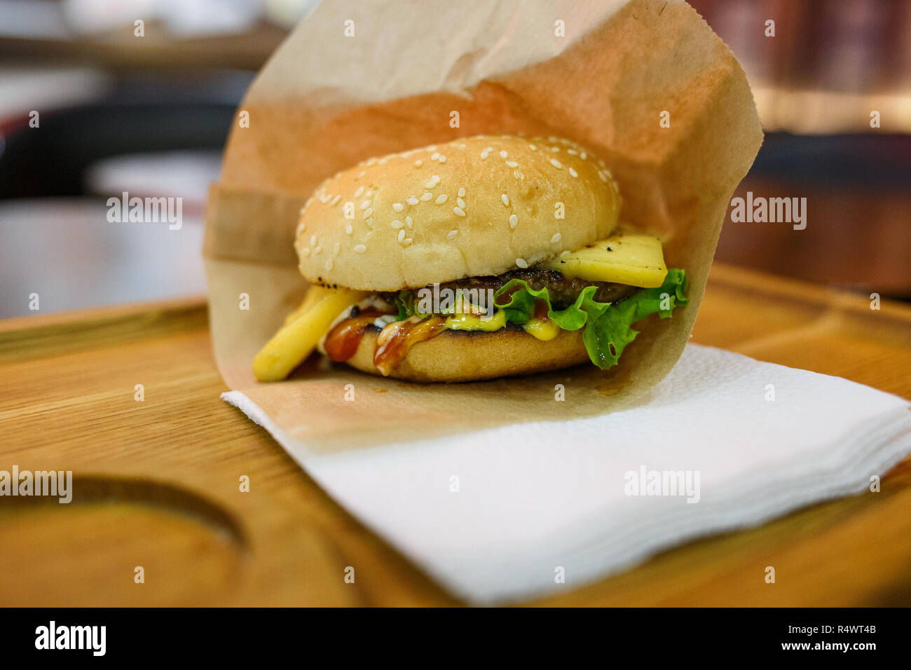 Cheeseburger in paper wrapping on the table Stock Photo - Alamy