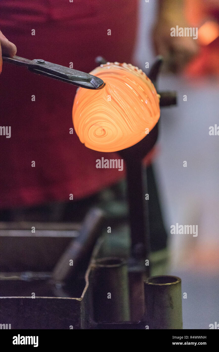 glass blower carefully forming hot glass to a decorative vase, germany ...