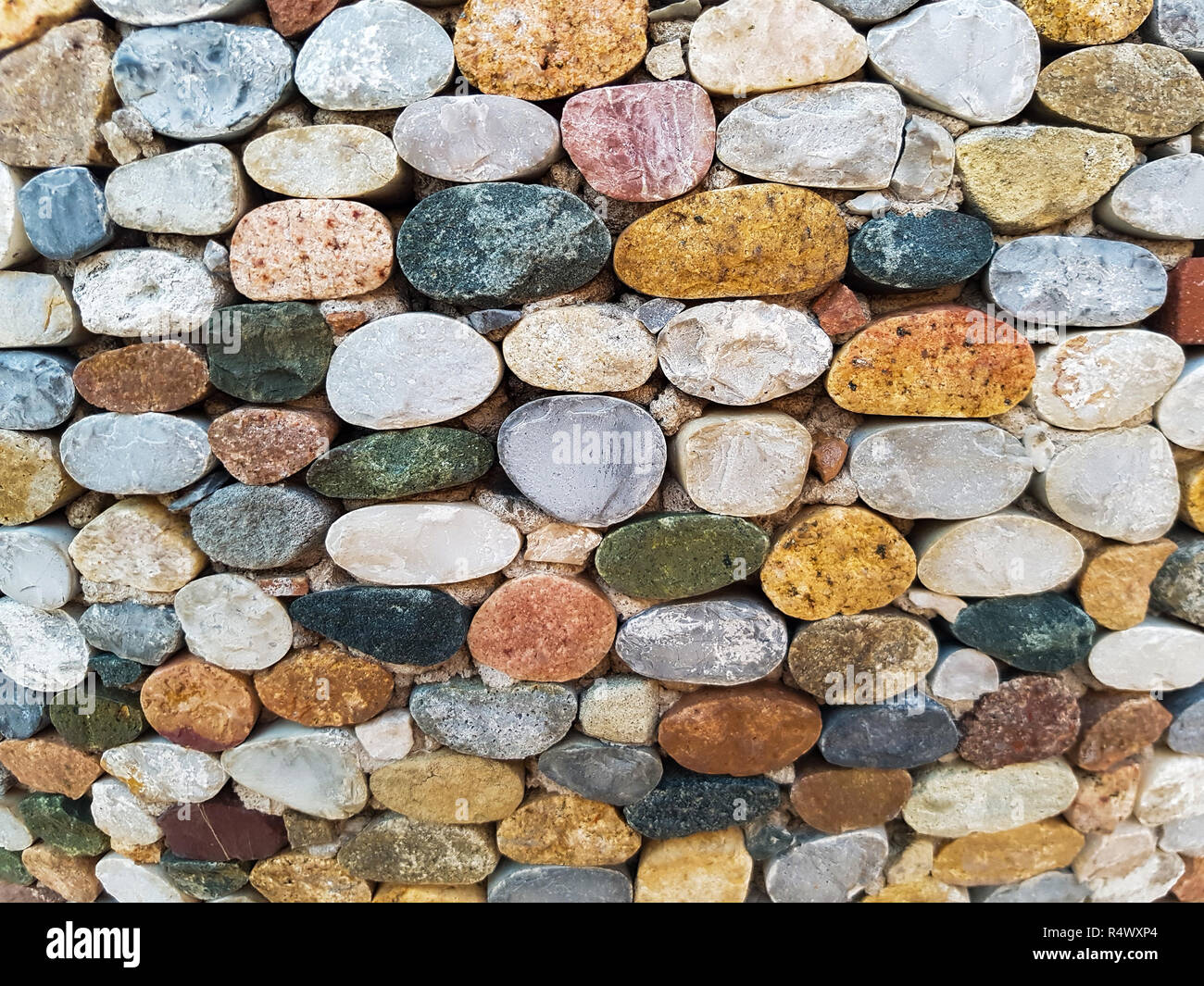 Detail of the colorful round stones wall backdrop Stock Photo - Alamy