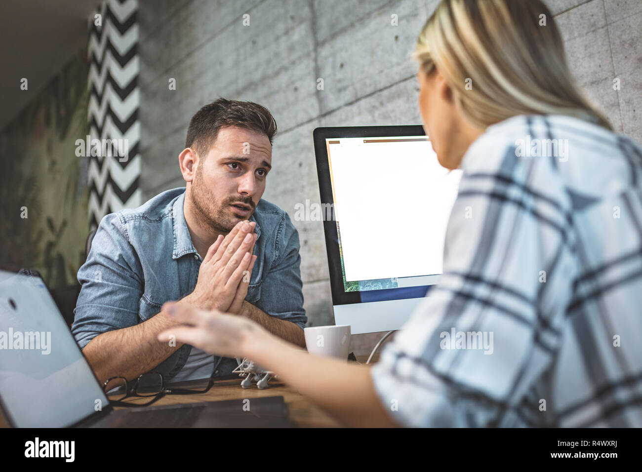 Young worried architect colleagues talking while working on a new ...