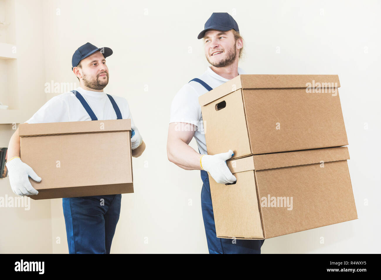 Delivery man loading cardboard boxes for moving to an apartment ...