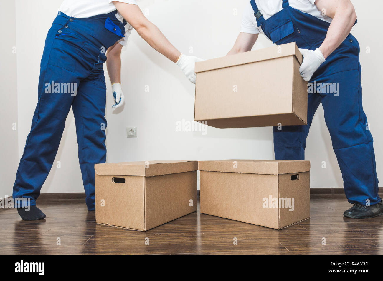 Delivery man loading cardboard boxes for moving to an apartment ...