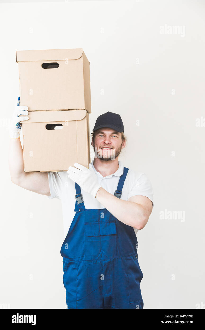 Delivery strong, muscular man loading cardboard boxes for moving to an ...