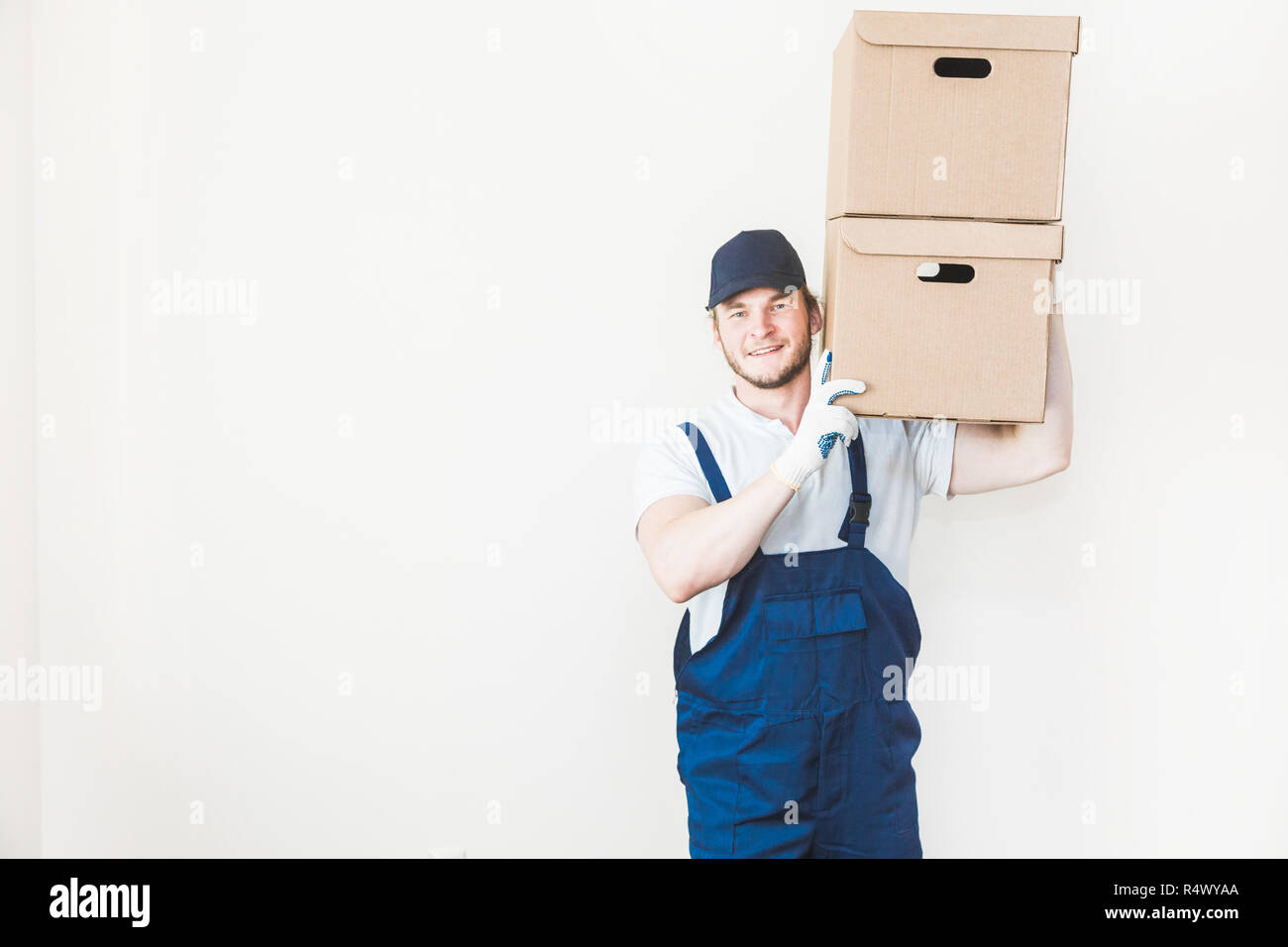Delivery strong, muscular man loading cardboard boxes for moving to an ...