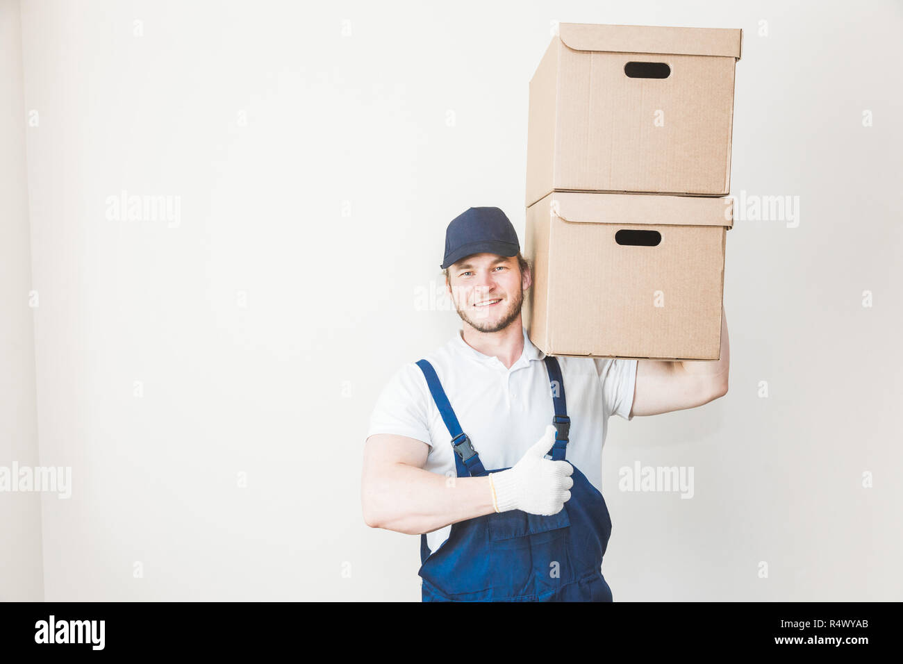 Delivery strong, muscular man loading cardboard boxes for moving to an ...