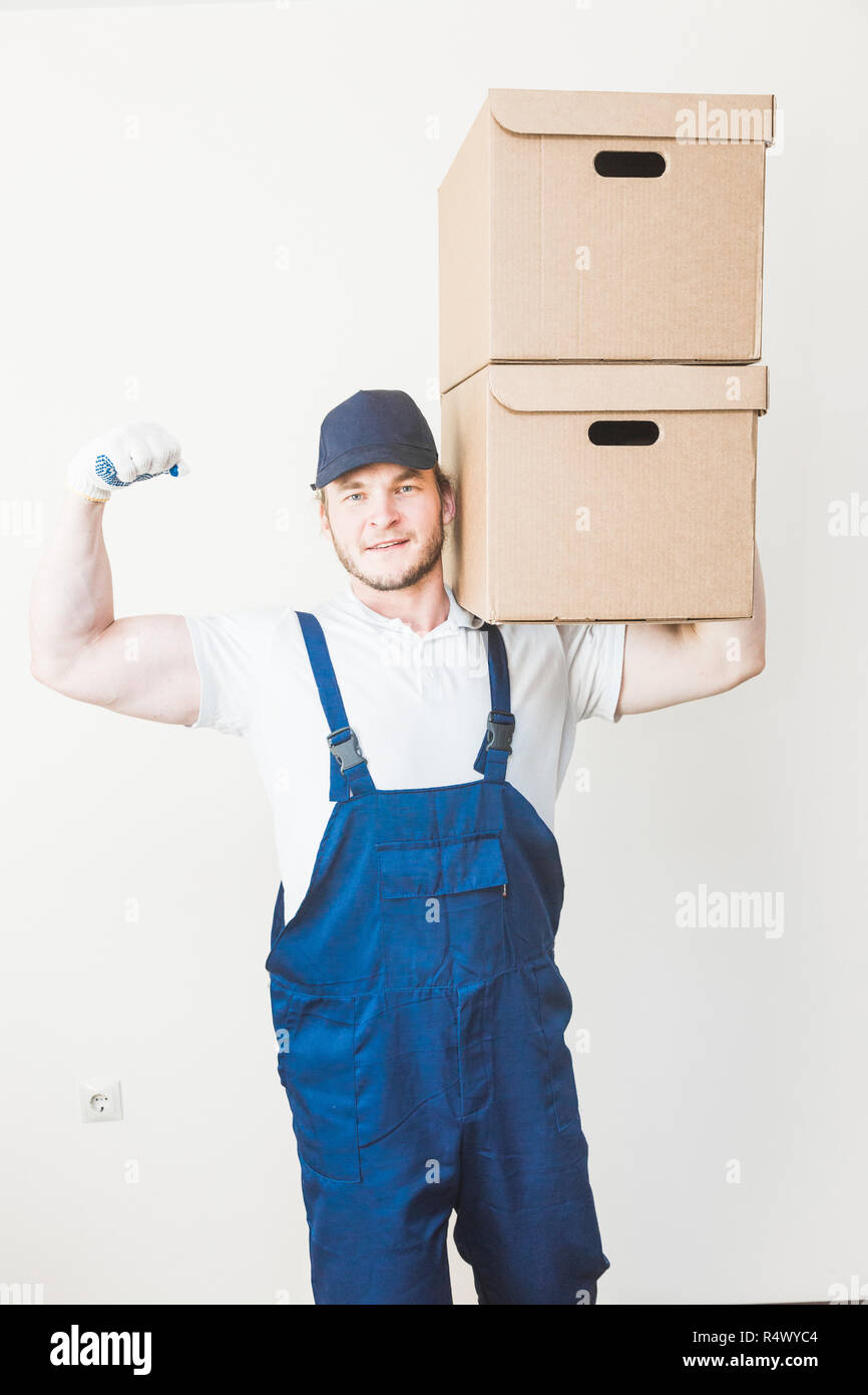 Delivery strong, muscular man loading cardboard boxes for moving to an ...
