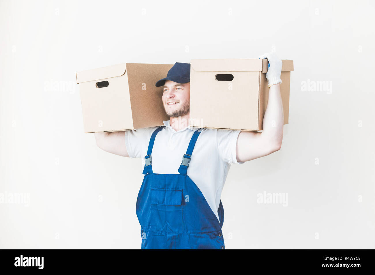 Delivery strong, muscular man loading cardboard boxes for moving to an ...