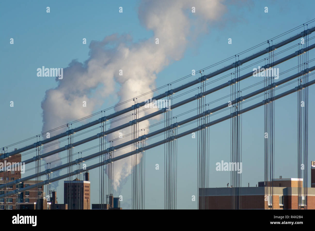 Detail of the cables on the Manhattan Bridge with smoking chimney ...