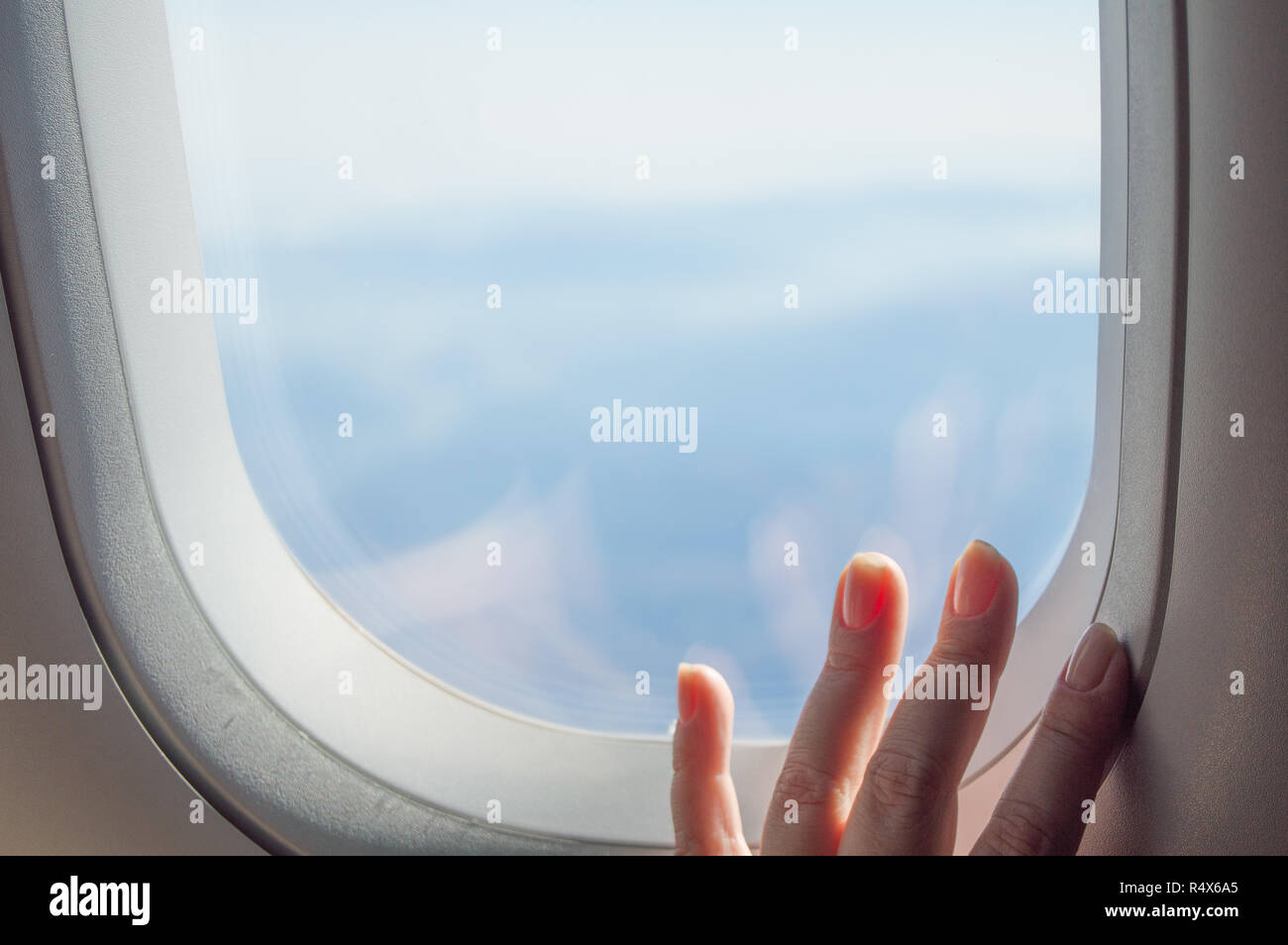 A female passenger of the flight sitting near the window, holding a ...