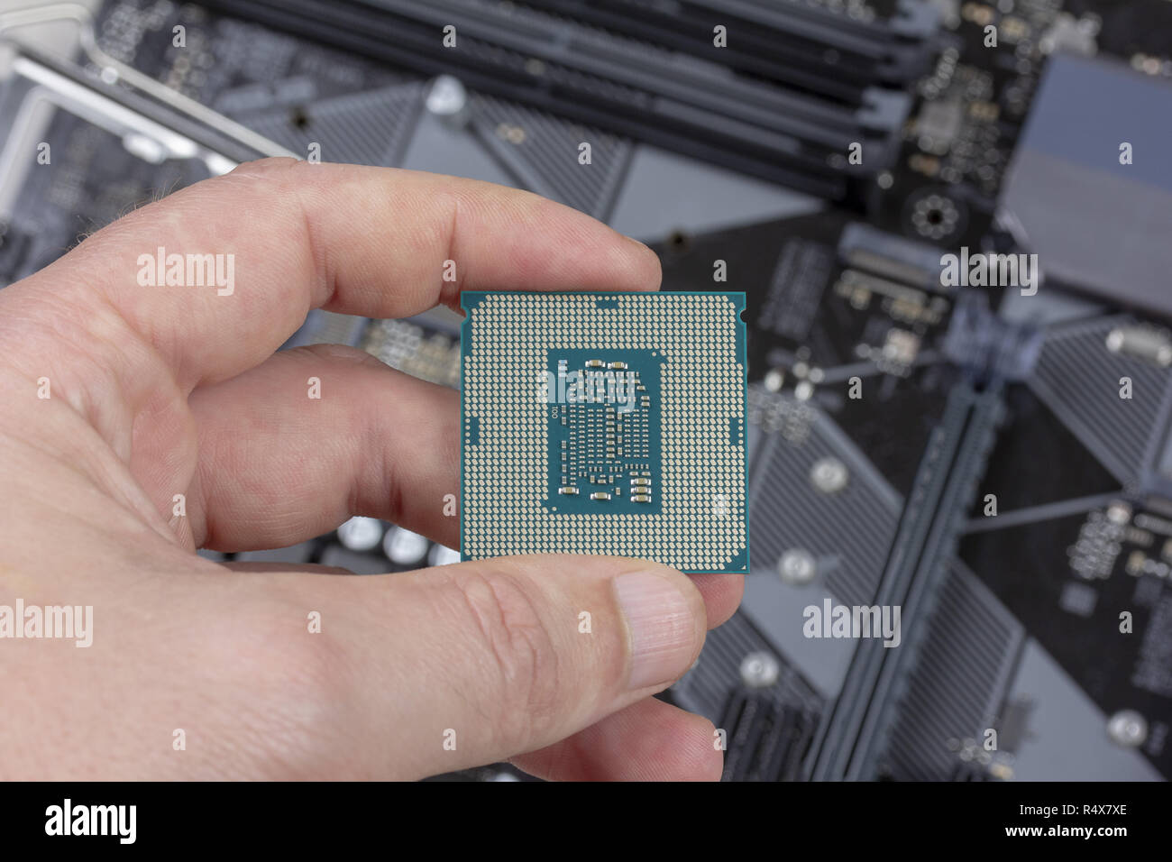 man holding fingers desktop processor 8th gen on background motherboard ...
