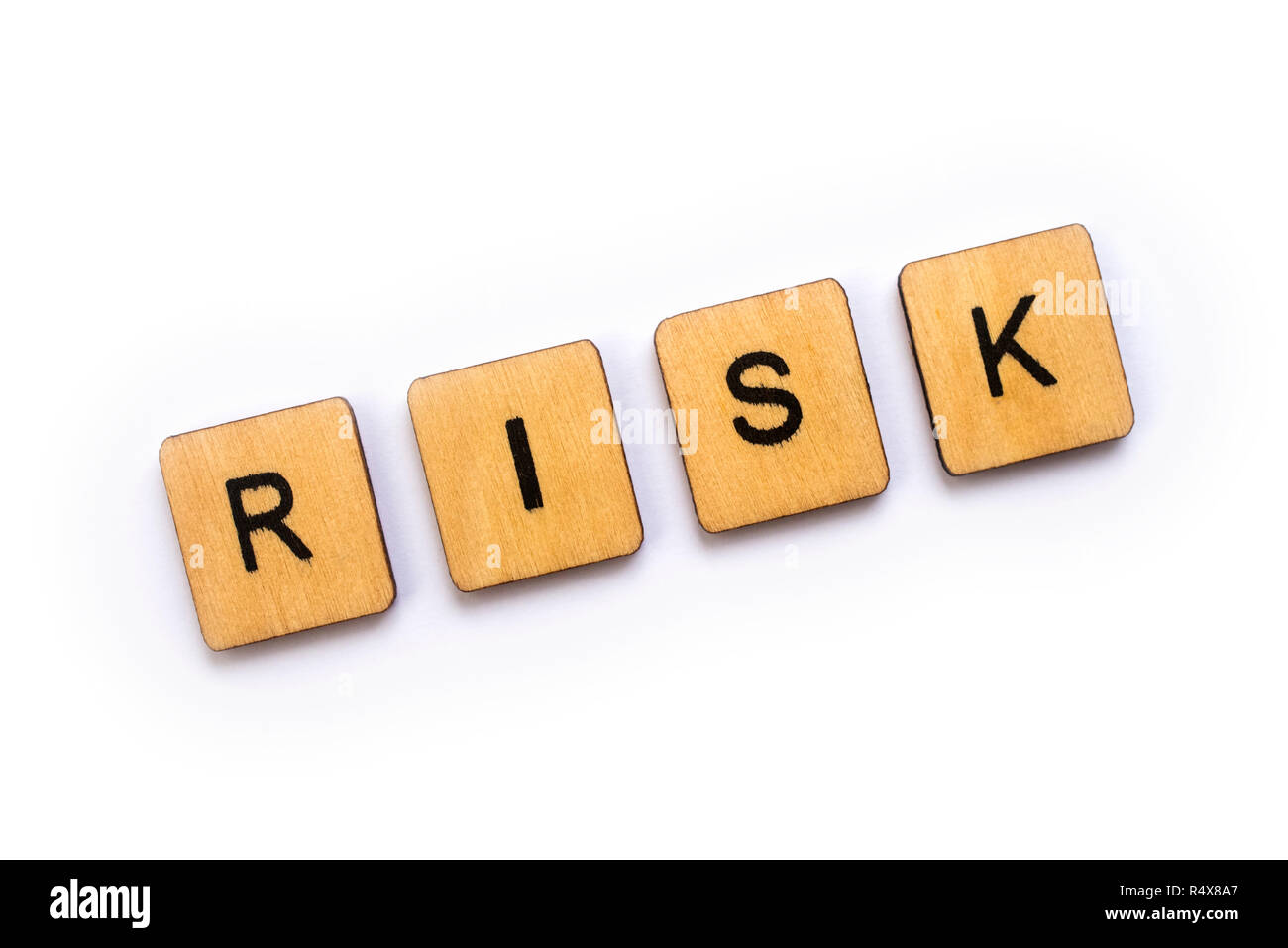 The word RISK, spelt with wooden letter tiles Stock Photo - Alamy