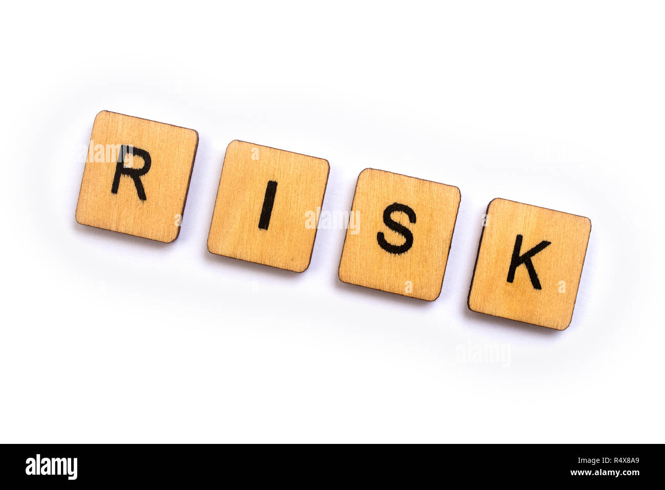 The word RISK, spelt with wooden letter tiles Stock Photo - Alamy