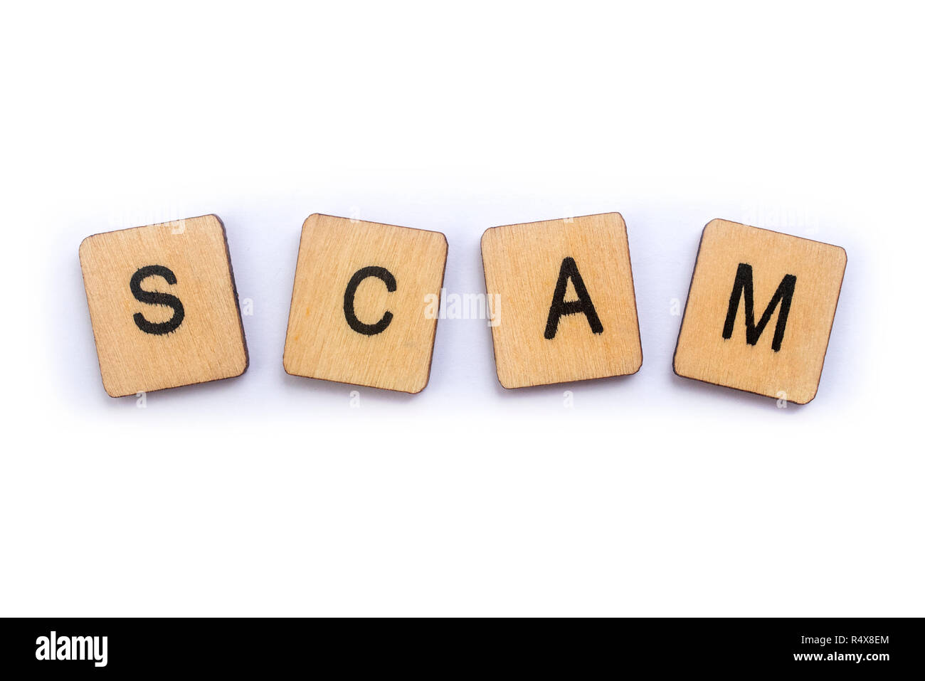 The word SCAM, spelt with wooden letter tiles Stock Photo - Alamy