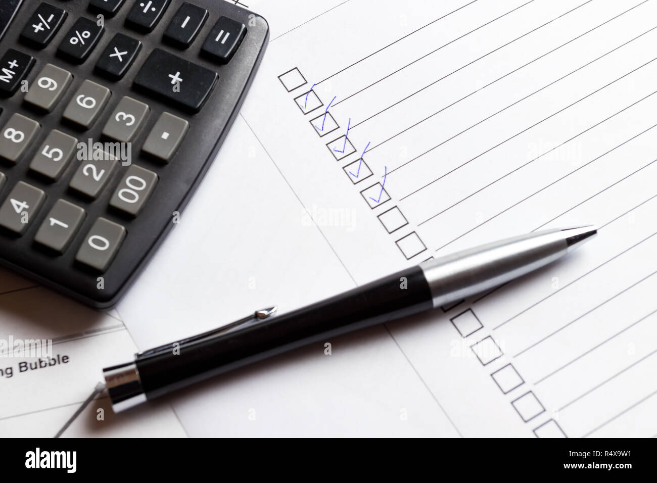 Ticked boxes on check list with elegant pen and calculator. Financial ...