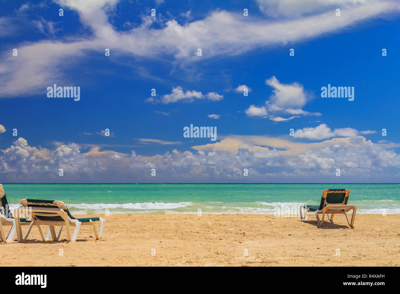 Beach chairs by the turquoise water of the Caribbean sea on a tropical ...