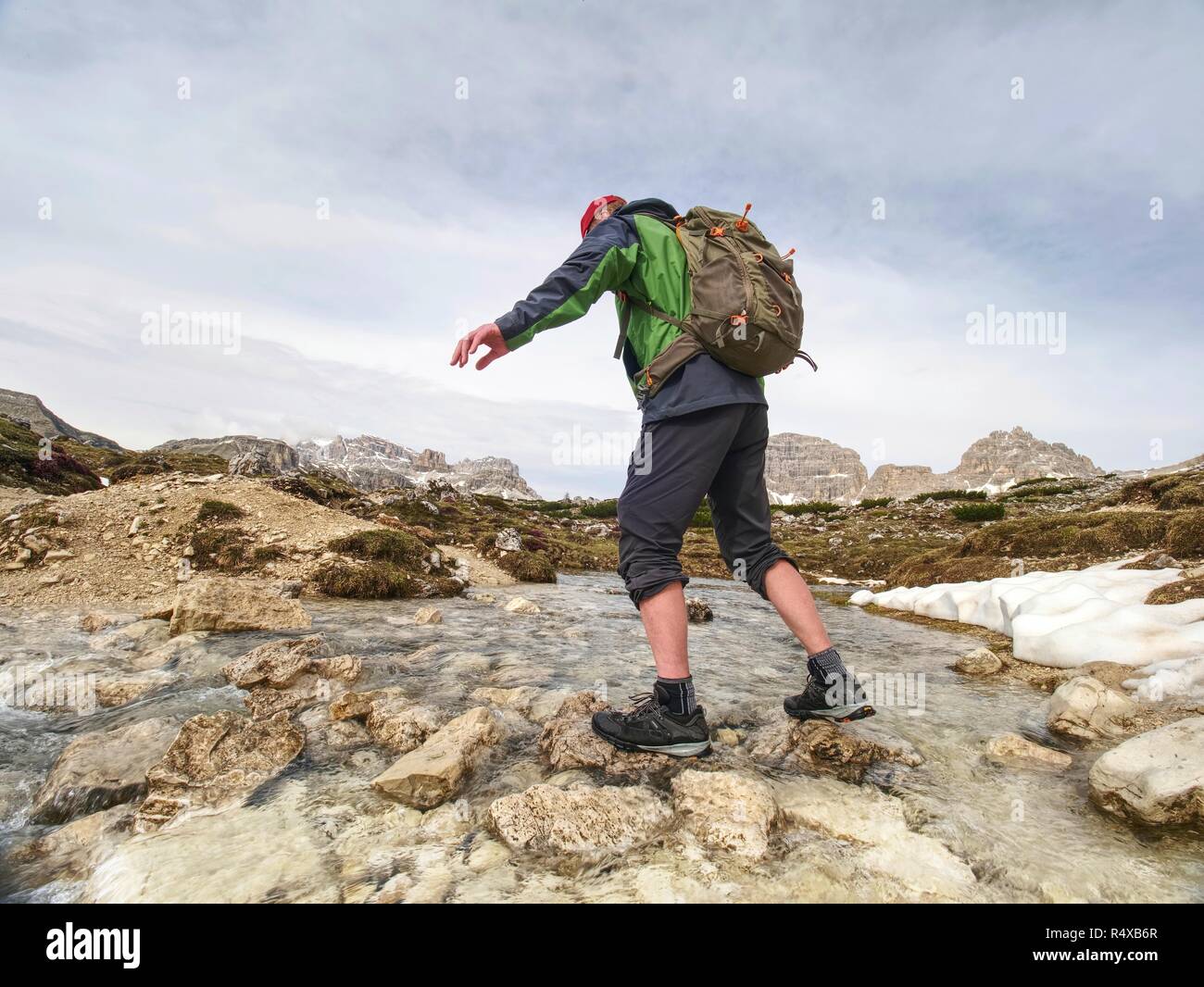 Hiker with backpack traveling in spring Dolomiti mountains. Cold cloudy ...