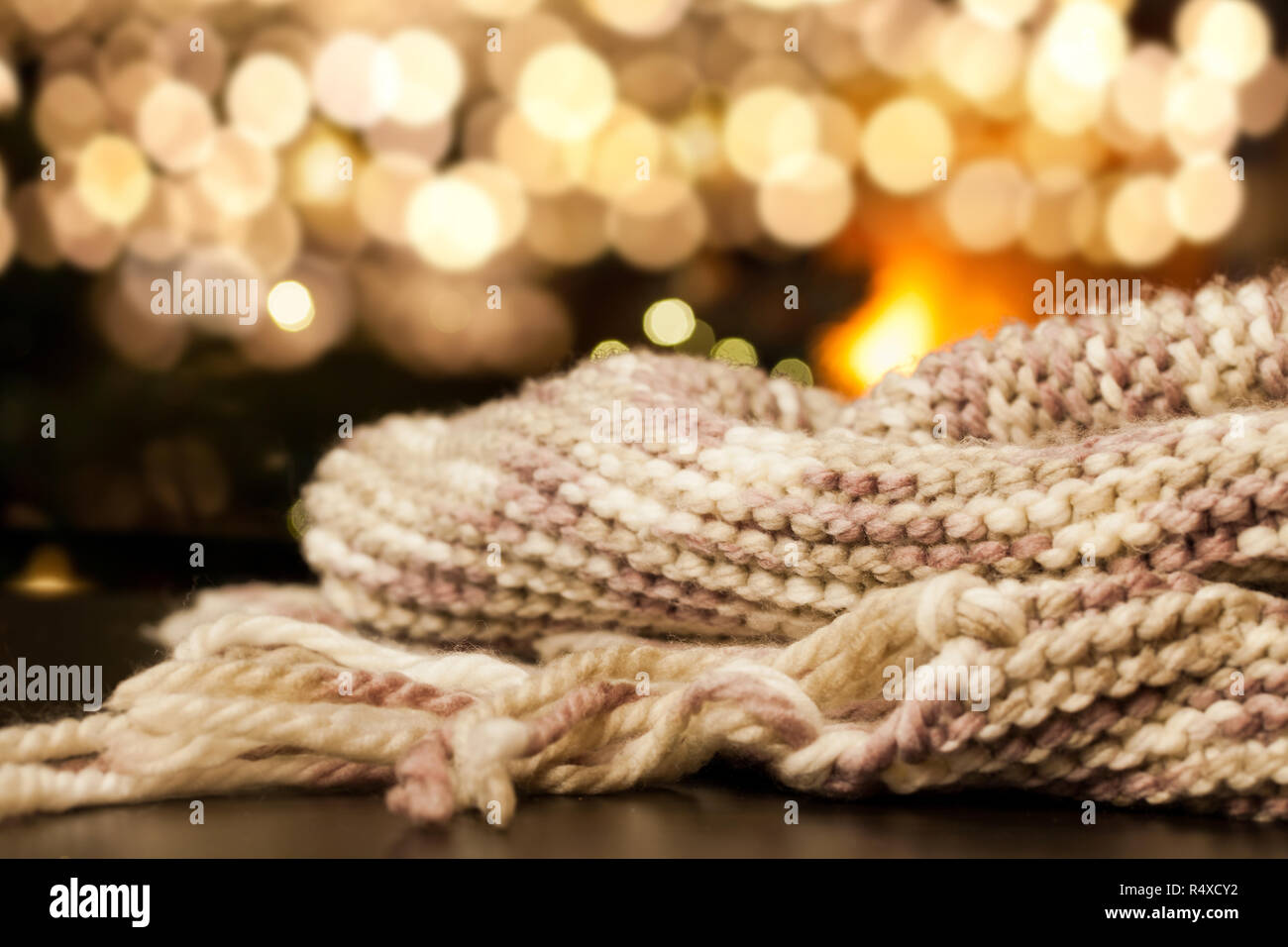 warm knitted scarf on chair, christmas tree and burning fireplace in ...