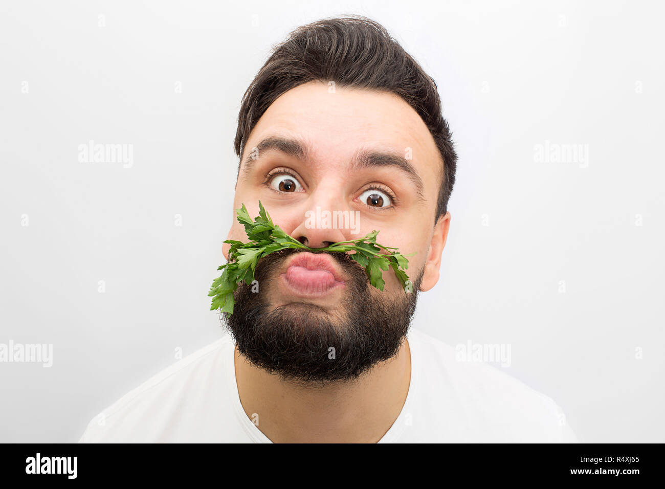 Picture of funny young man standing and lookin at camera. He makes ...