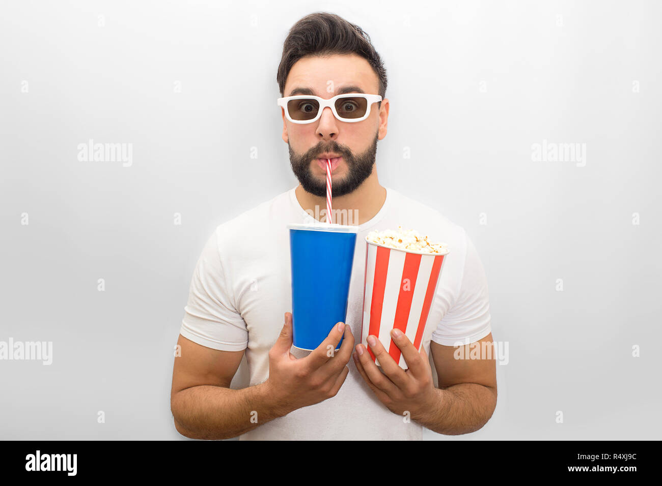 Confident young man looks on camera through movie glasses. He holds ...