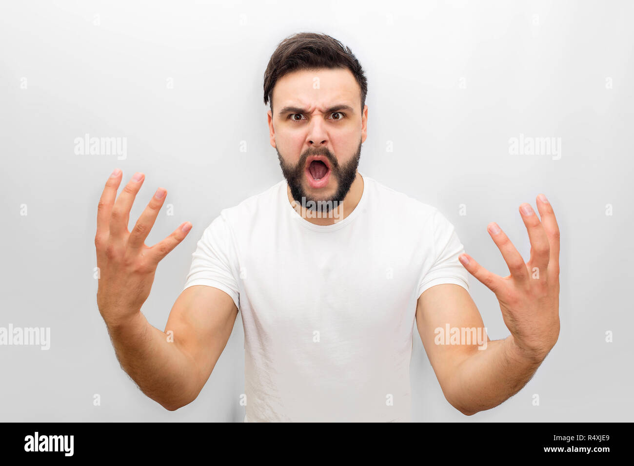 Emotional and angry young man looks at camera. He is expressing his ...