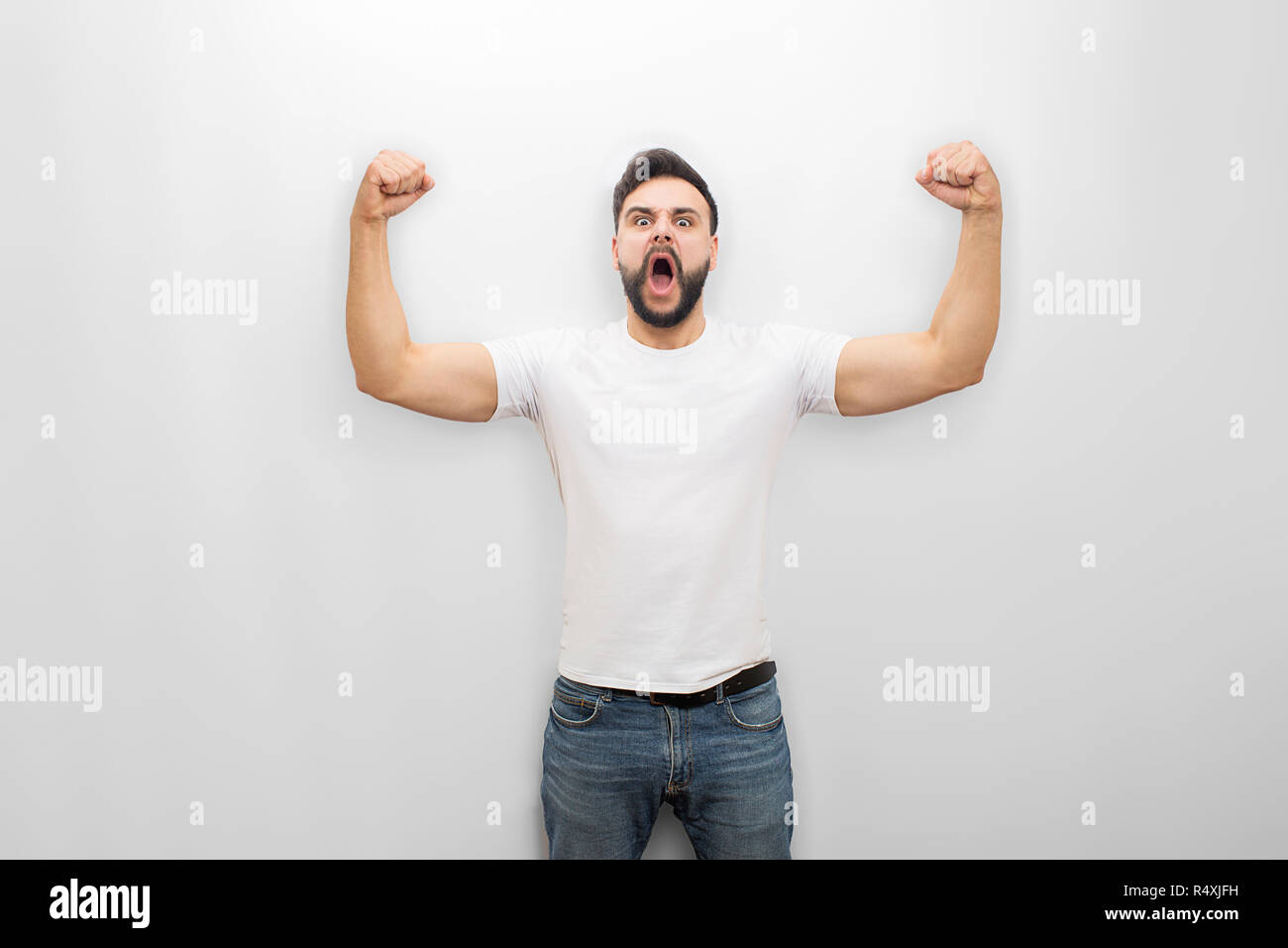 Young man screaming and yelling while posing. He is strong. Guy shows ...