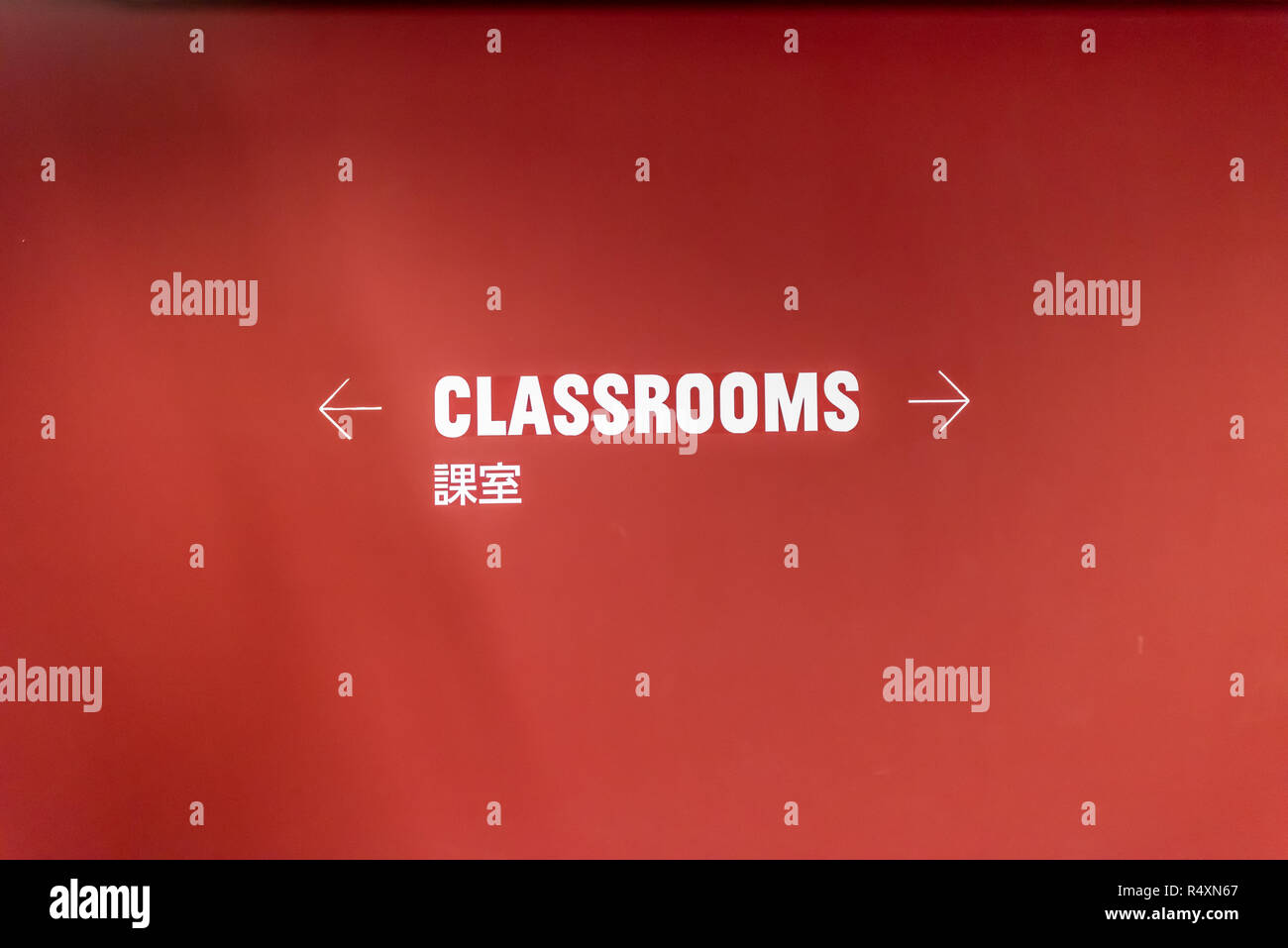 Red wall with direction pointing to classroom Stock Photo - Alamy