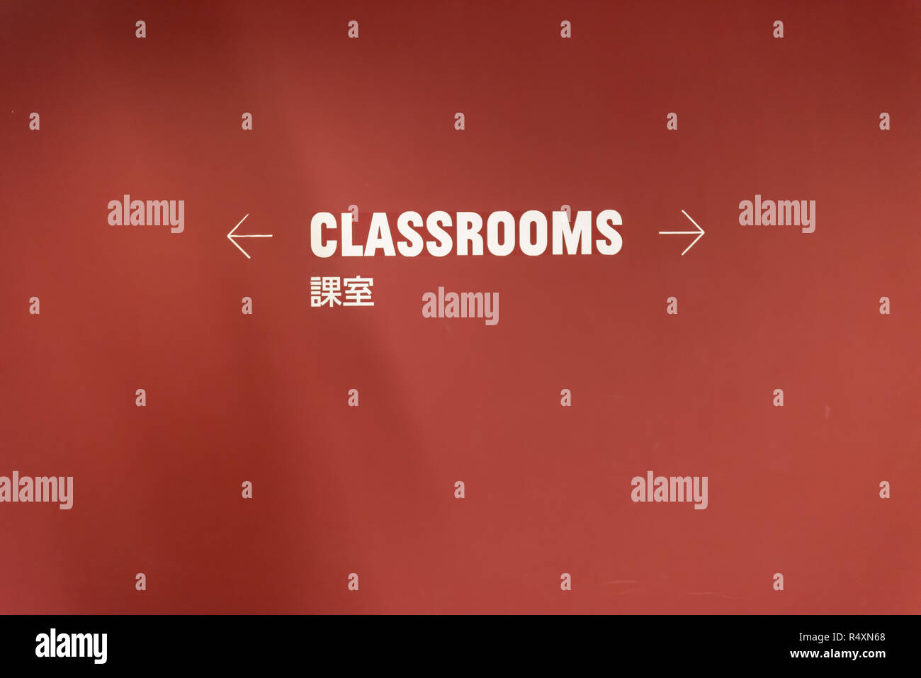 Red wall with direction pointing to classroom Stock Photo - Alamy