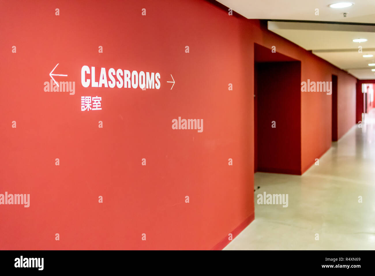 Red wall with direction pointing to classroom Stock Photo - Alamy