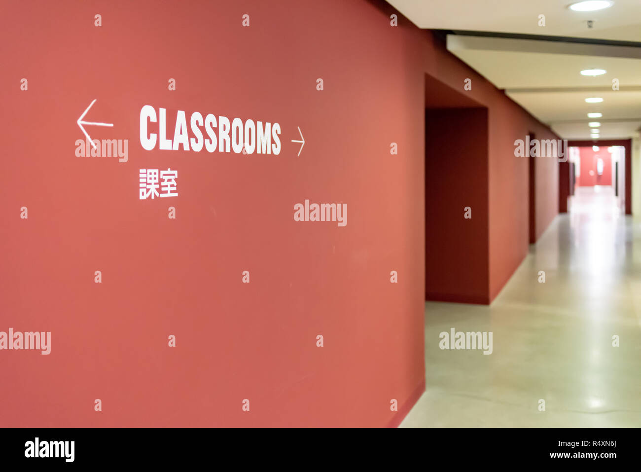 Red wall with direction pointing to classroom Stock Photo - Alamy