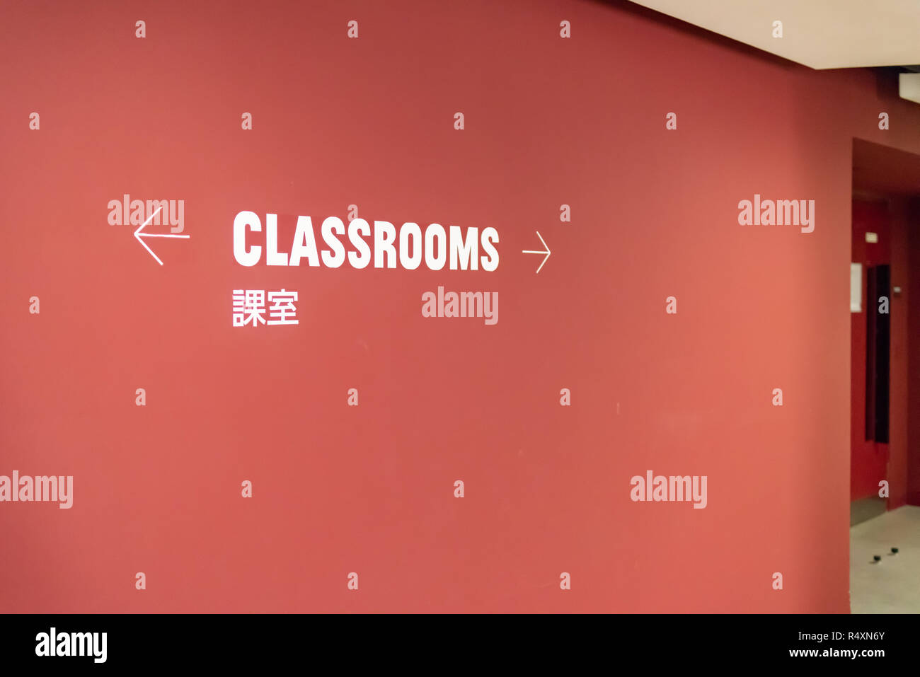 Red wall with direction pointing to classroom Stock Photo - Alamy