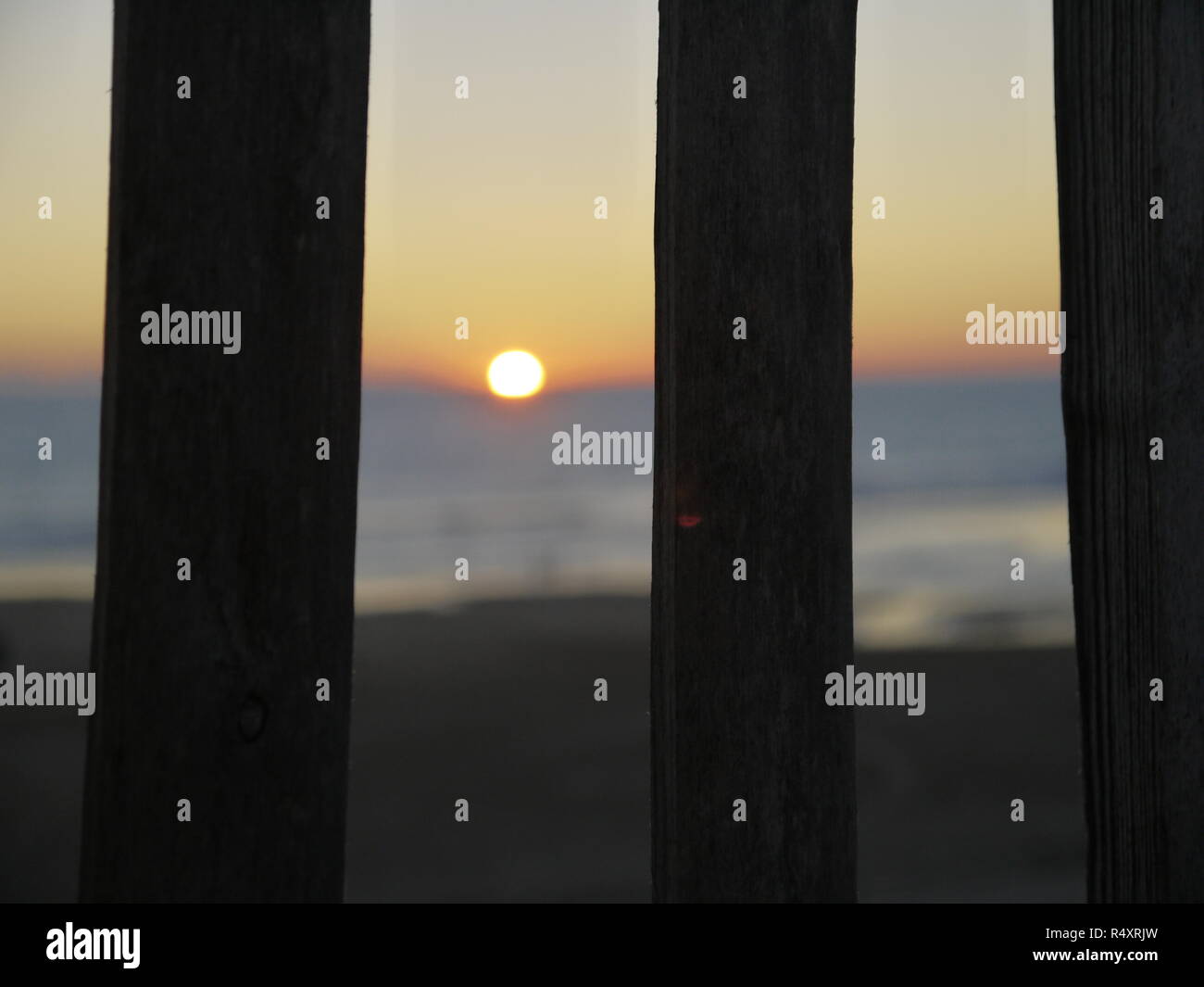 Sun through fence Stock Photo - Alamy
