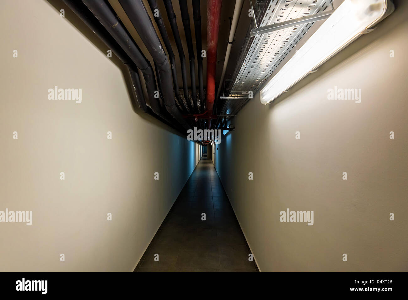 Narrow corridor at industrial site with many pipes on ceiling Stock ...